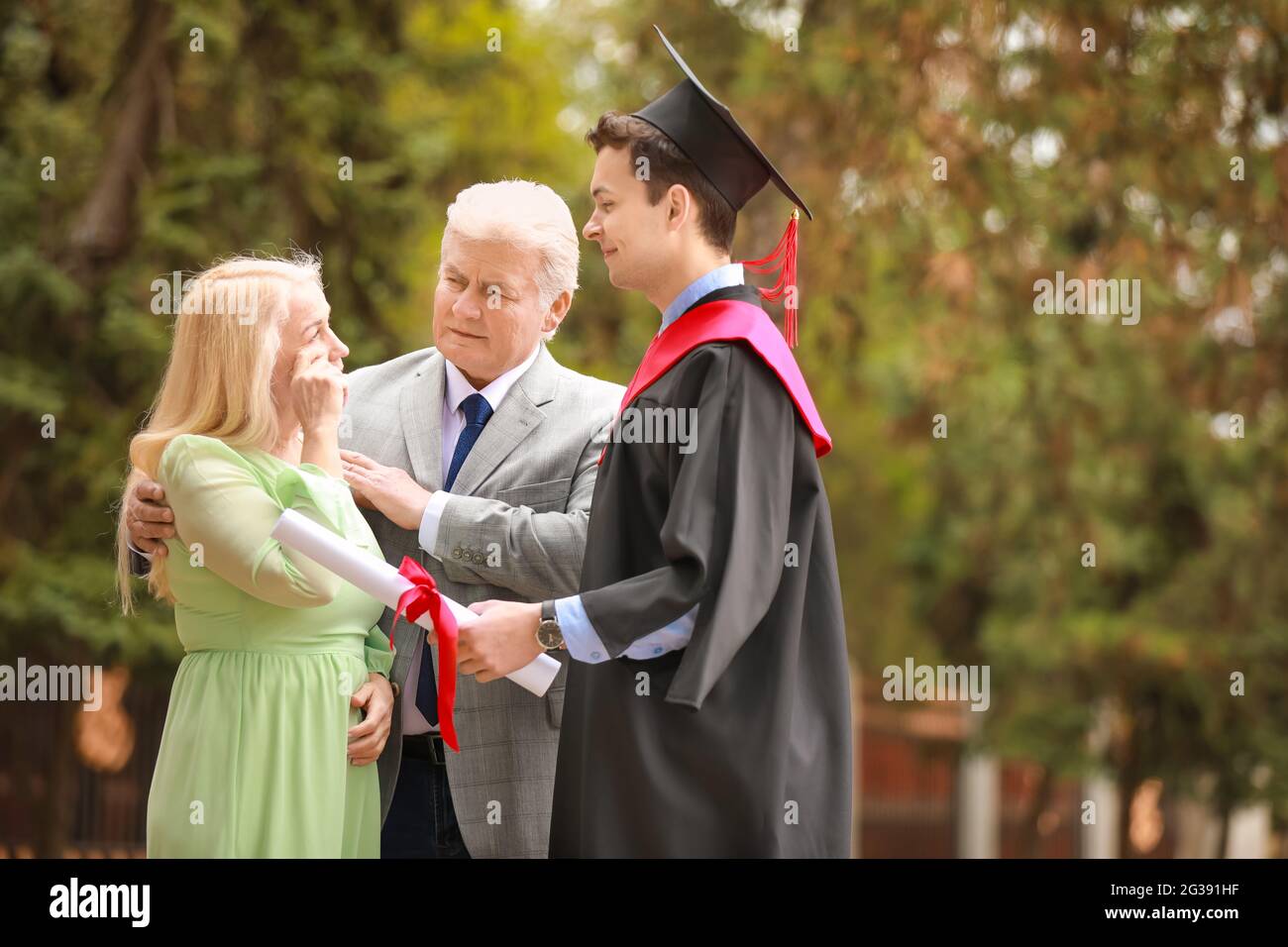 Happy young man with his parents on graduation day Stock Photo - Alamy