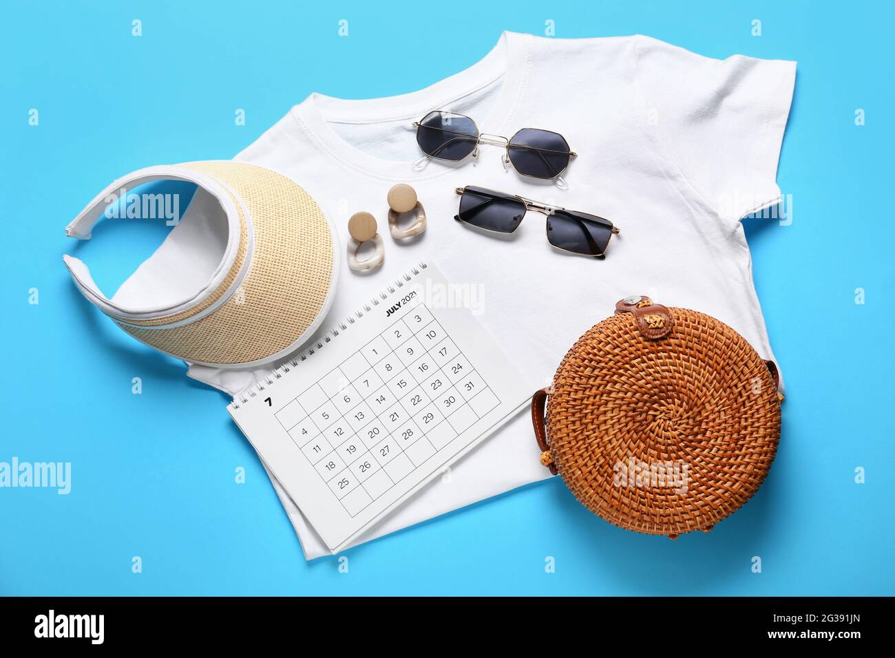 Calendar, t-shirt and beach accessories on color background Stock Photo ...