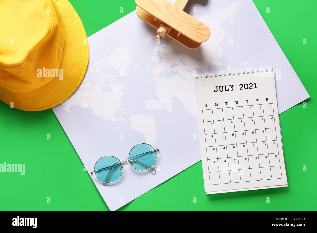 Calendar, world map and travel accessories on color background Stock ...