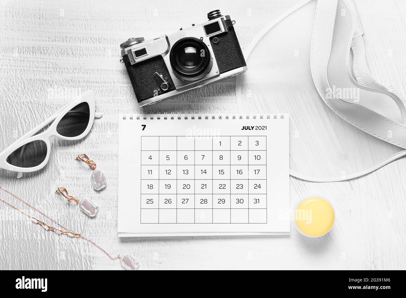 Calendar, photo camera and female accessories on light background Stock ...