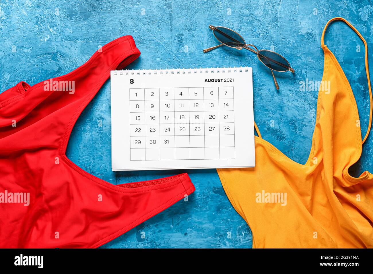 Calendar and beach accessories on color background Stock Photo - Alamy