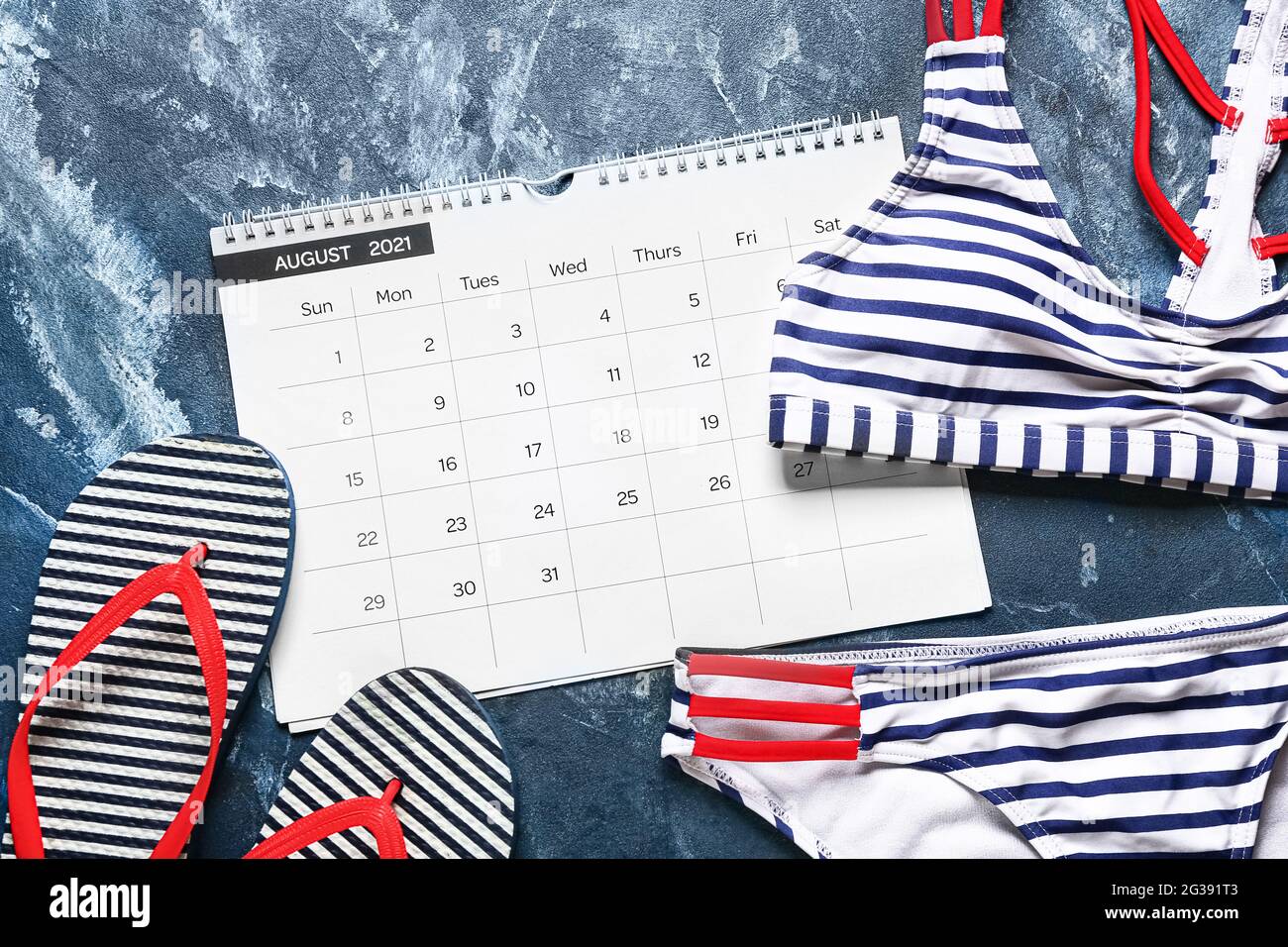 Calendar, flip-flops and swimsuit on color background Stock Photo - Alamy