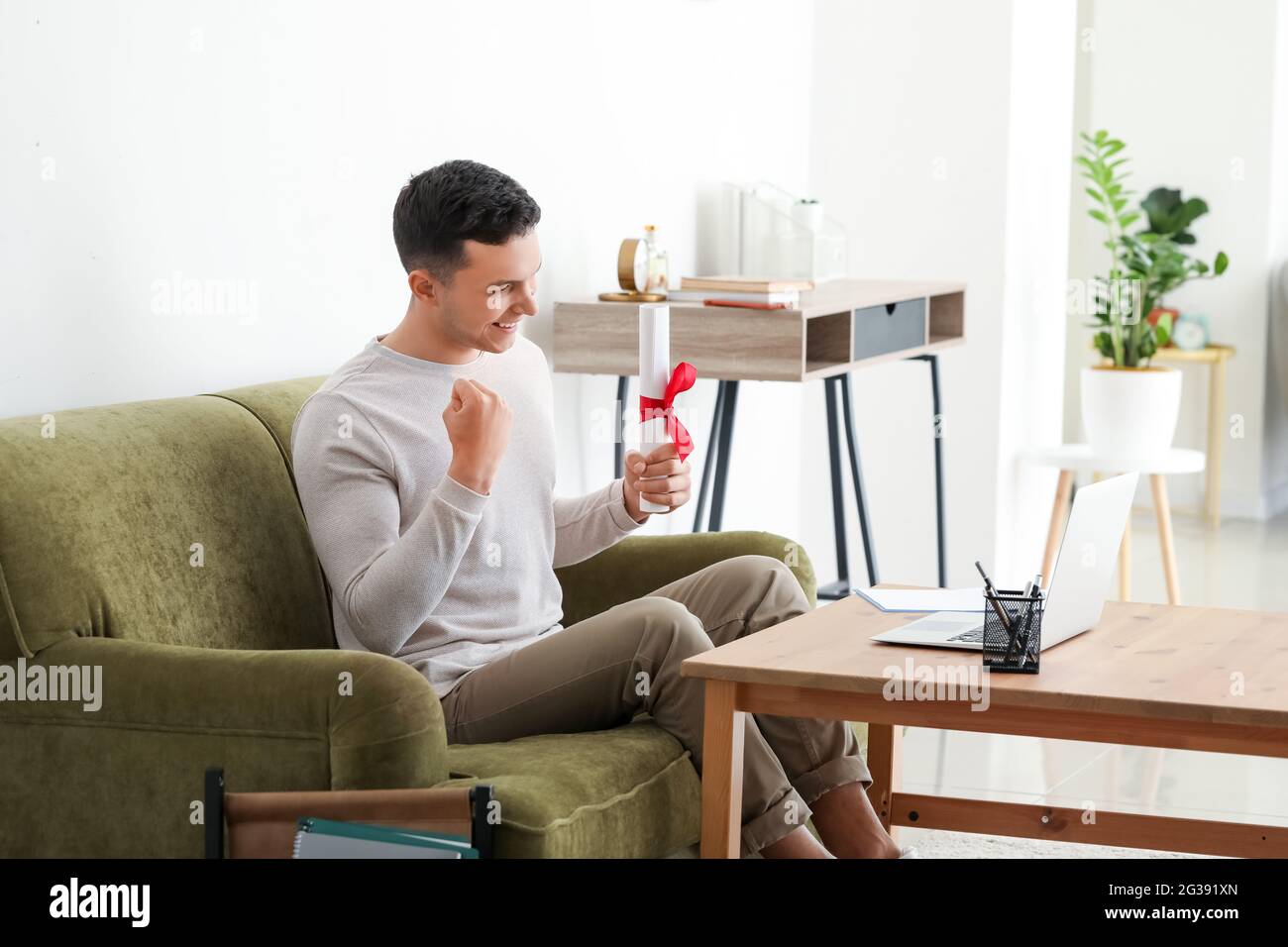 Happy male student on his graduation day at home. Concept of online ...