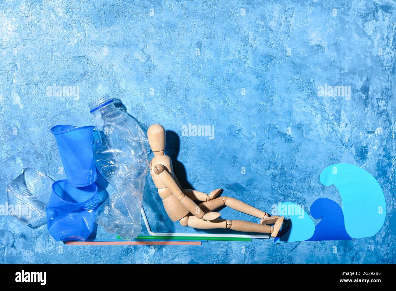 Mannequin with garbage and paper sea waves on color background. Ecology ...