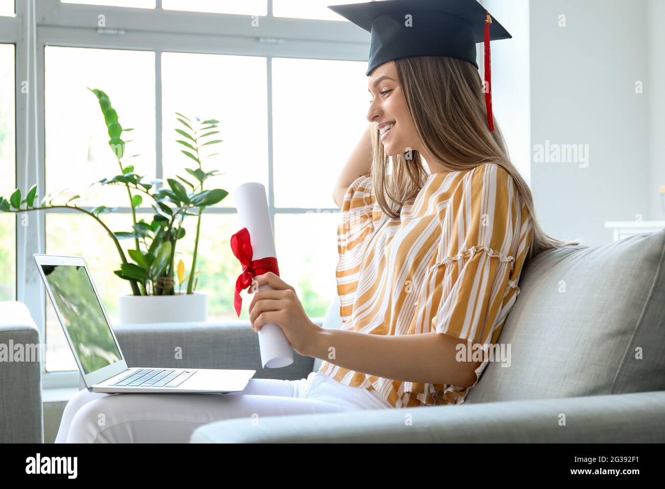 Happy female student on her graduation day at home. Concept of studying ...