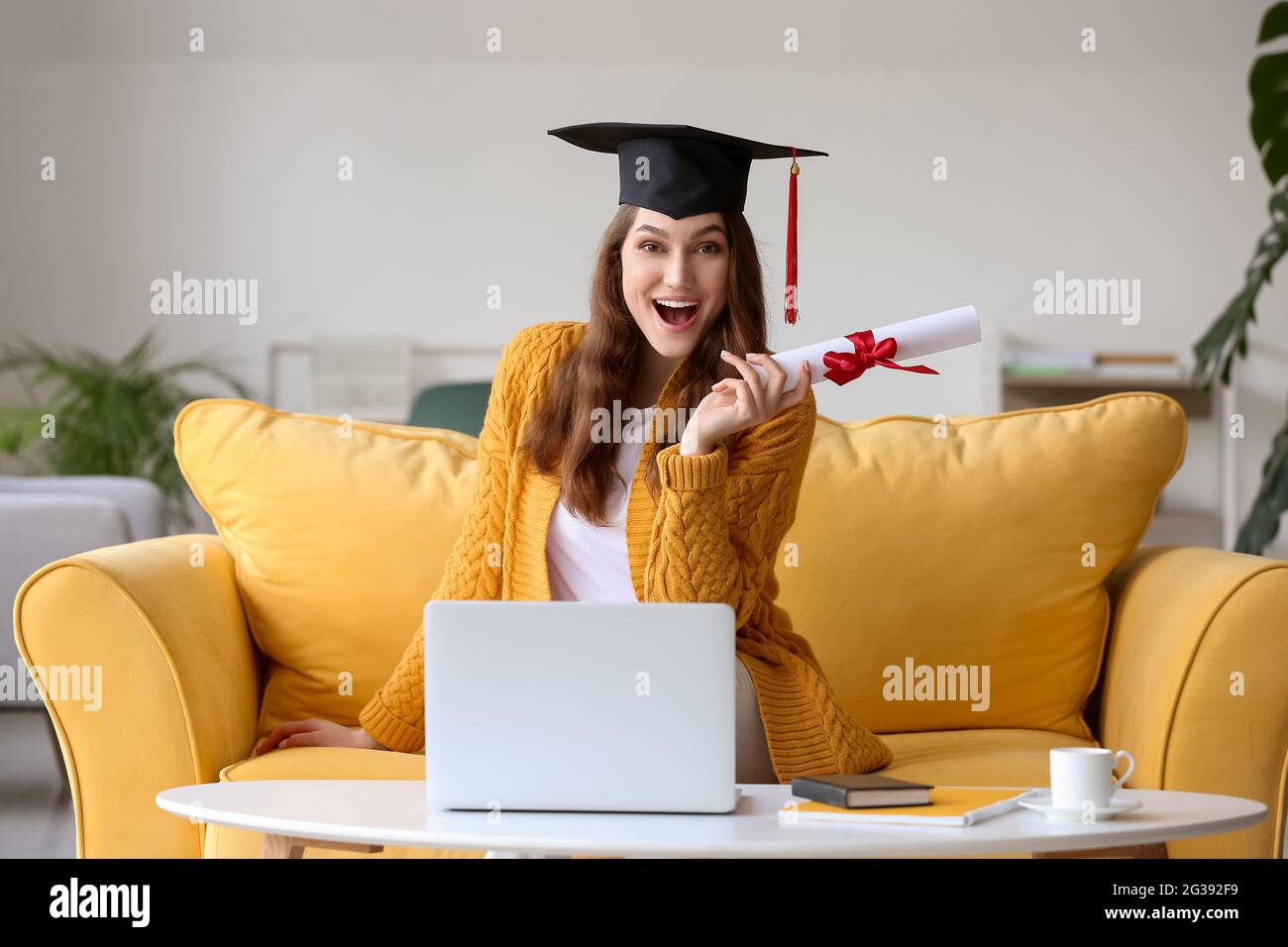 Happy female student on her graduation day at home. Concept of studying ...