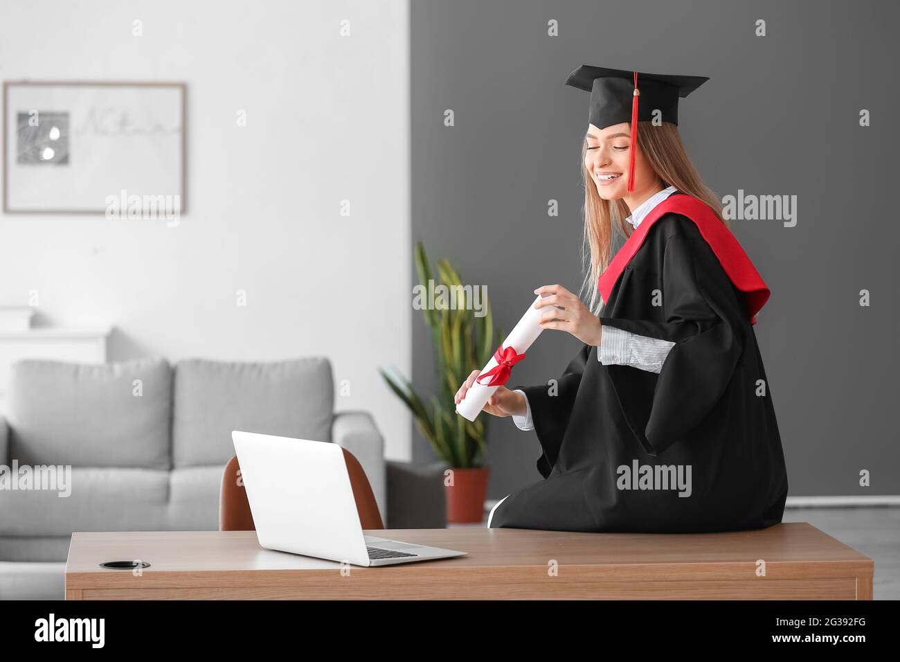 Happy female student on her graduation day at home. Concept of studying ...
