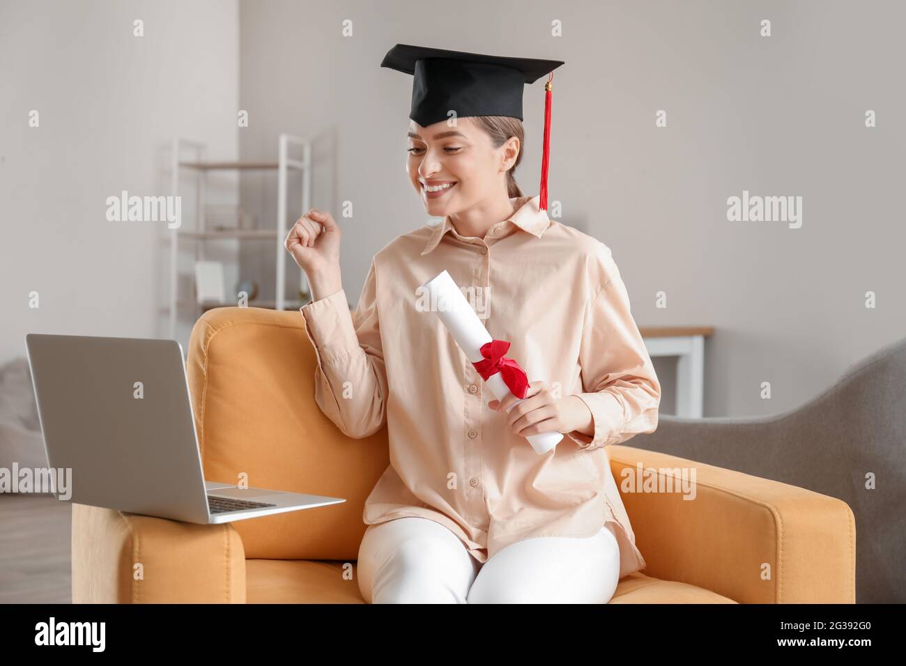 Happy female student on her graduation day at home. Concept of studying ...