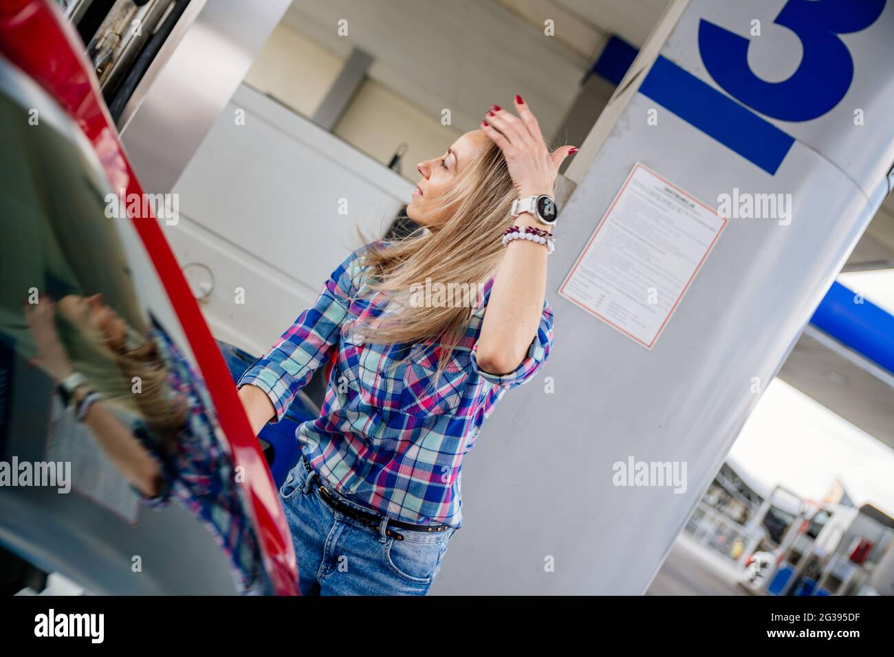 Beautiful woman refueling the gas tank at fuel pump Stock Photo - Alamy