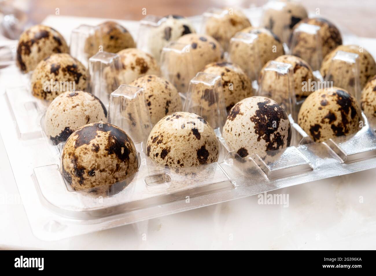 Fresh small spotted partridge eggs in tranparent plastic container ...