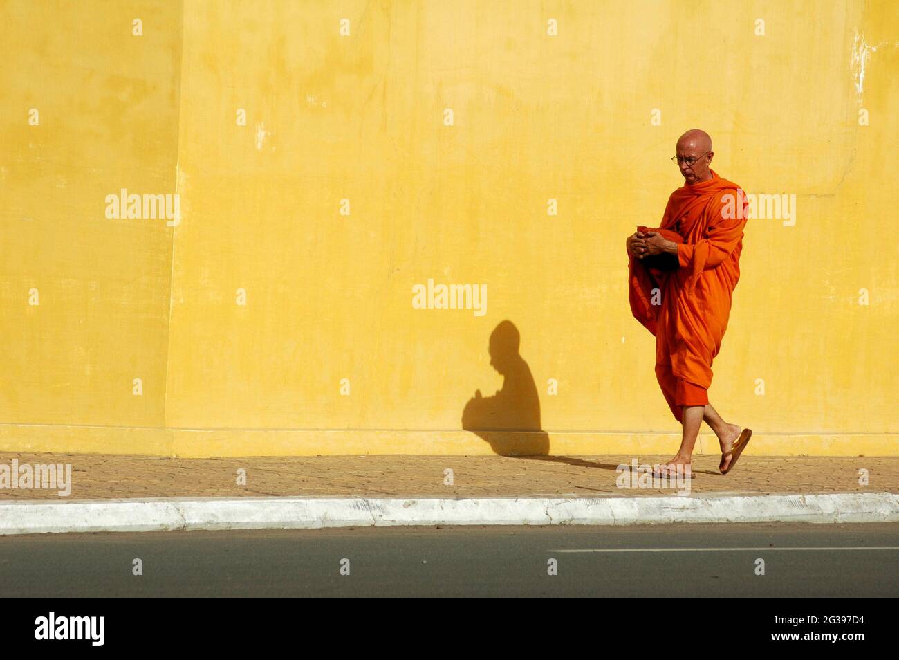 A foreign monk out collecting morning alms in from of the Royal Palace ...