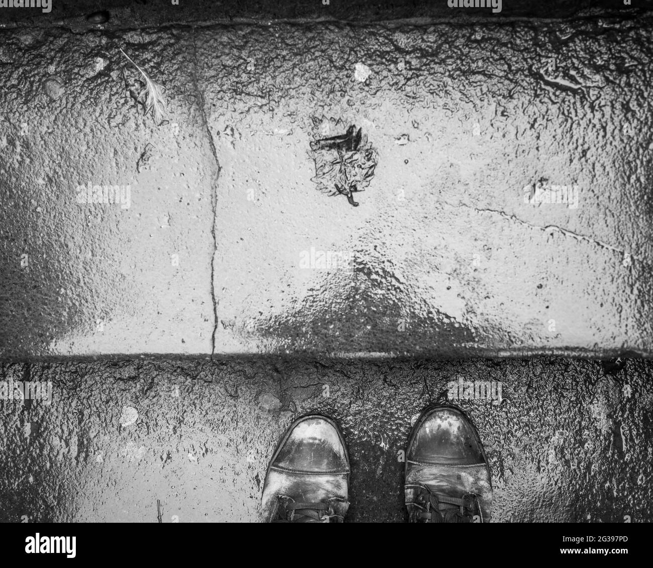 Grayscale shot of feet on the ground Stock Photo - Alamy