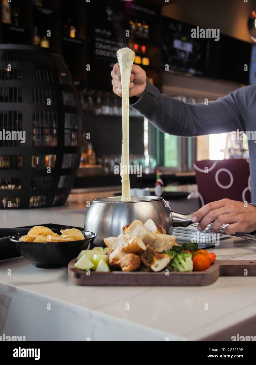 Unrecognizable man melting cheese in a restaurant Stock Photo - Alamy