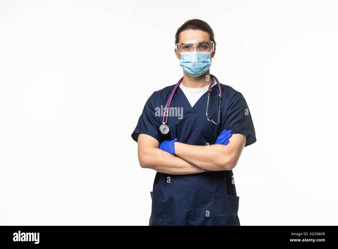 Portrait of handsome man in protective face mask with crossed arms ...