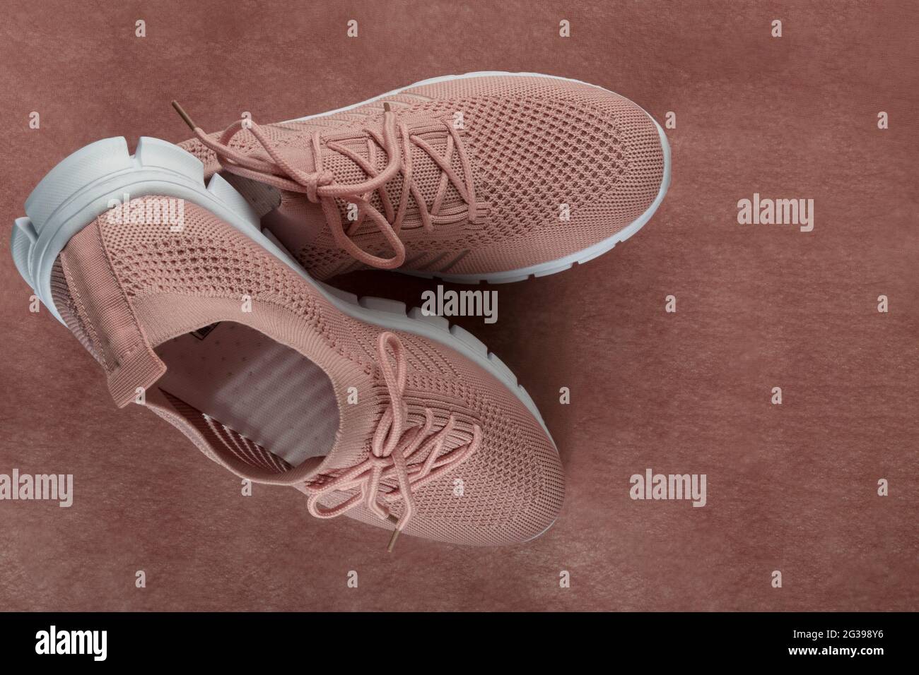 Pink women's shoes made of light soft fabric. Shoes lies on a light ...