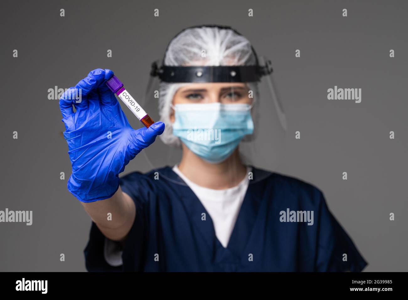 Young doctor holding a test tube blood sample of coronavirus wearing ...