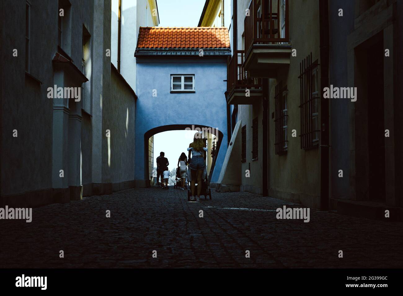 people walking through the small passage between buildings, streets of ...