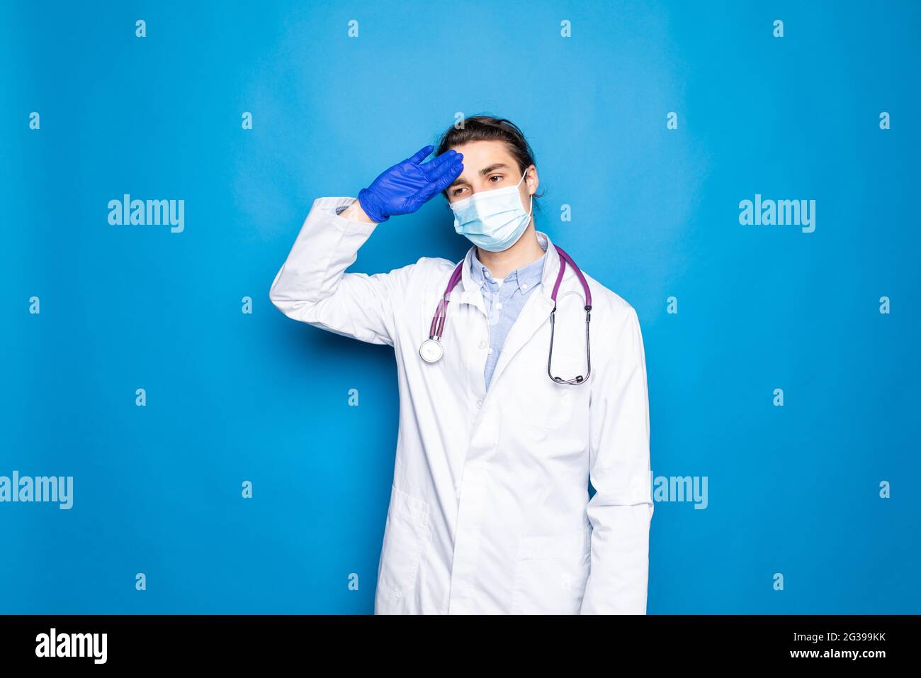 Frustrated doctor man in white wear over blue background. Doc is tired ...