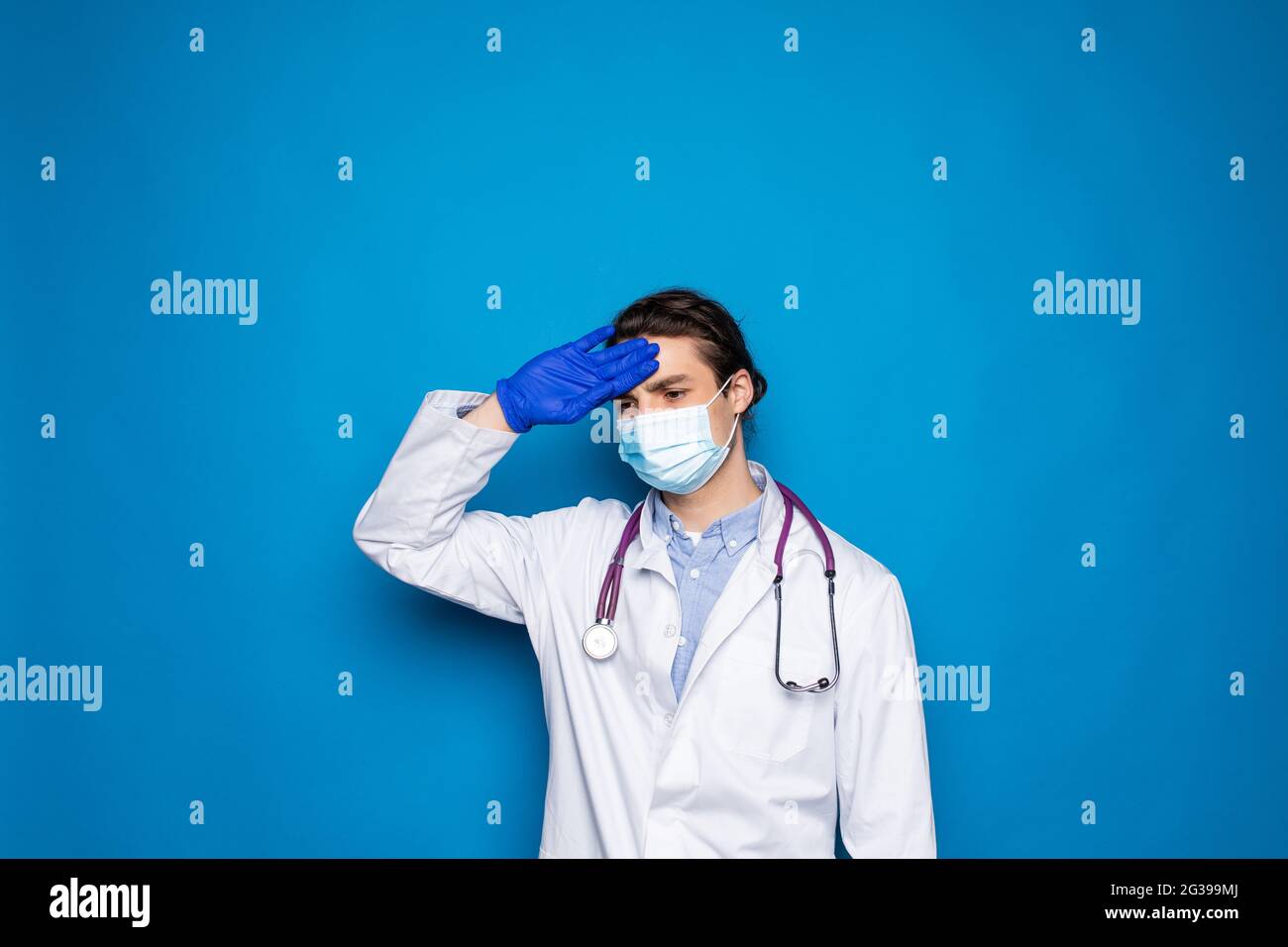 Frustrated doctor man in white wear over blue background. Doc is tired ...