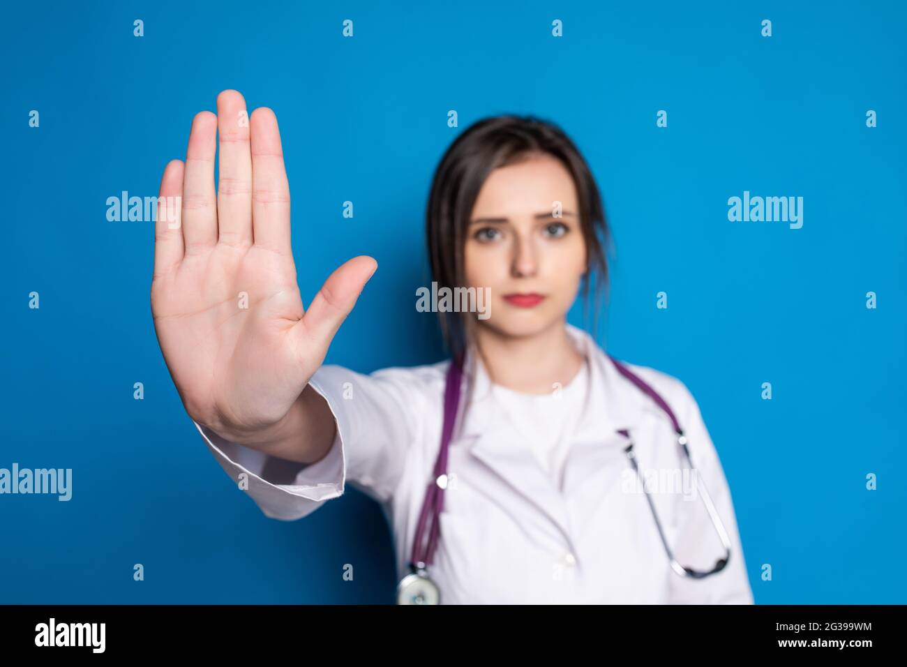 Young attractive woman doctor showing stop gesture refusing standing in ...