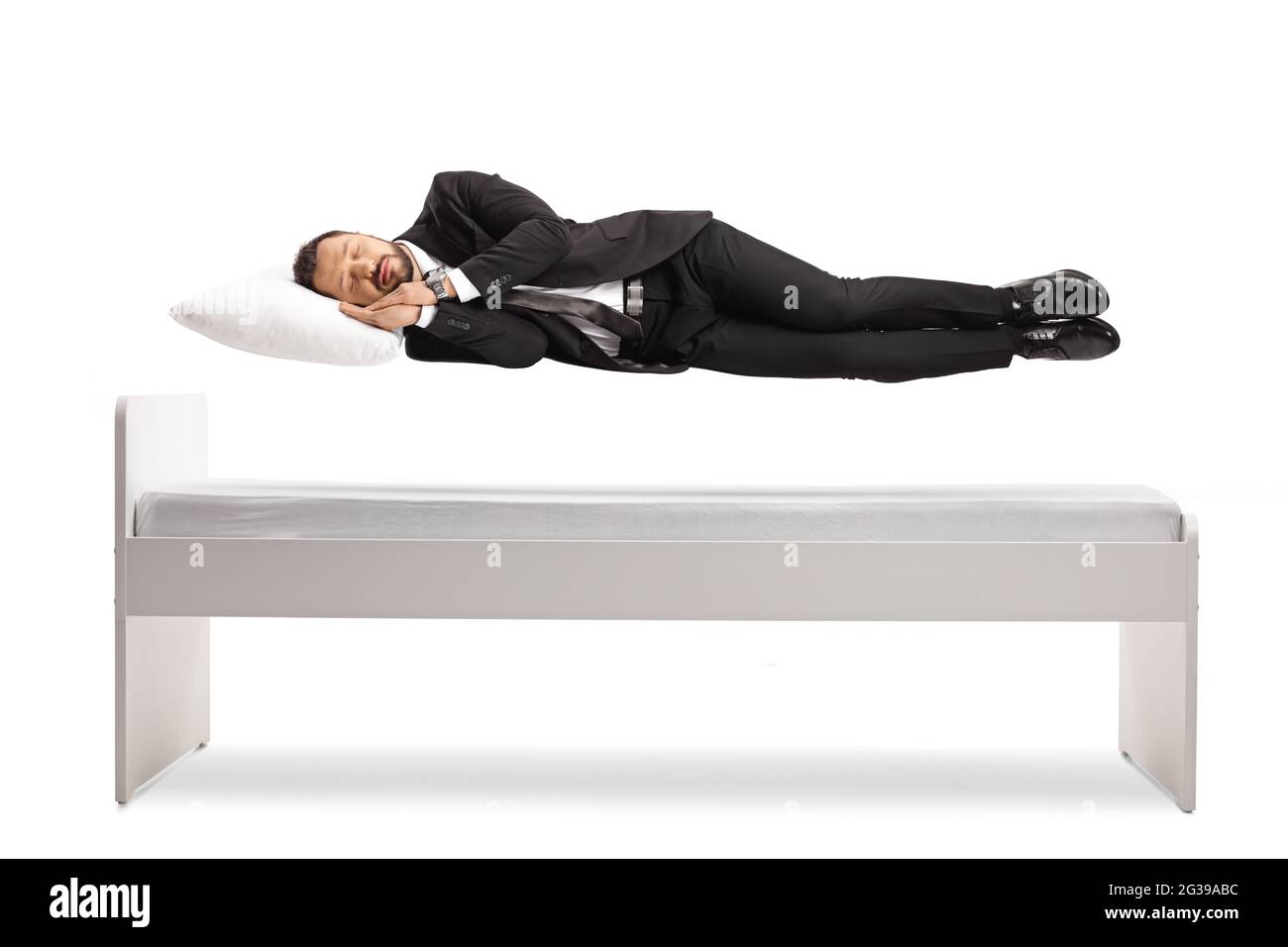 Man in a suit and tie sleeping and floating above his bed isolated on ...