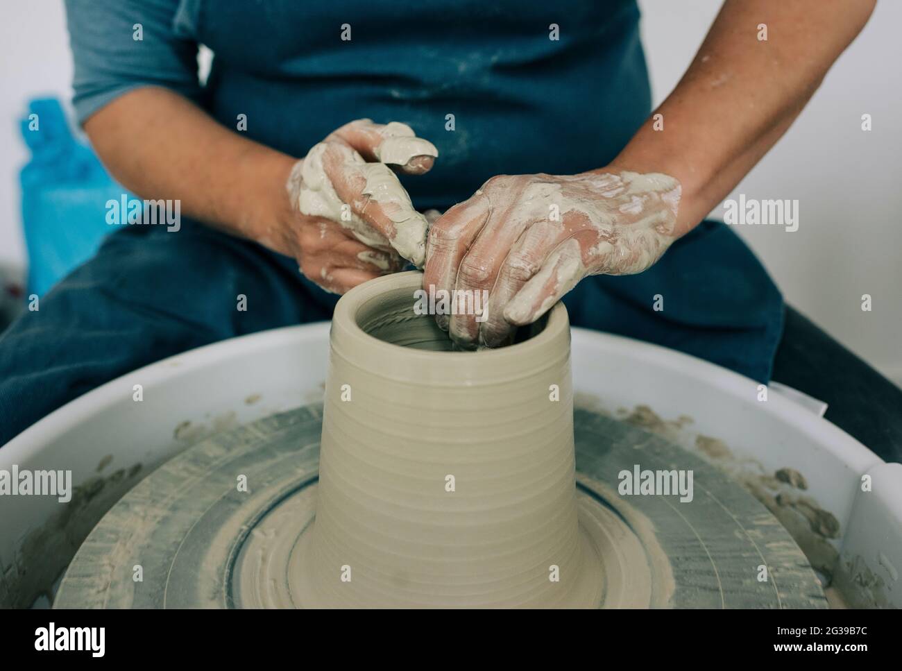 hand spinning clay on a pottery wheel in a home studio in the UK Stock ...