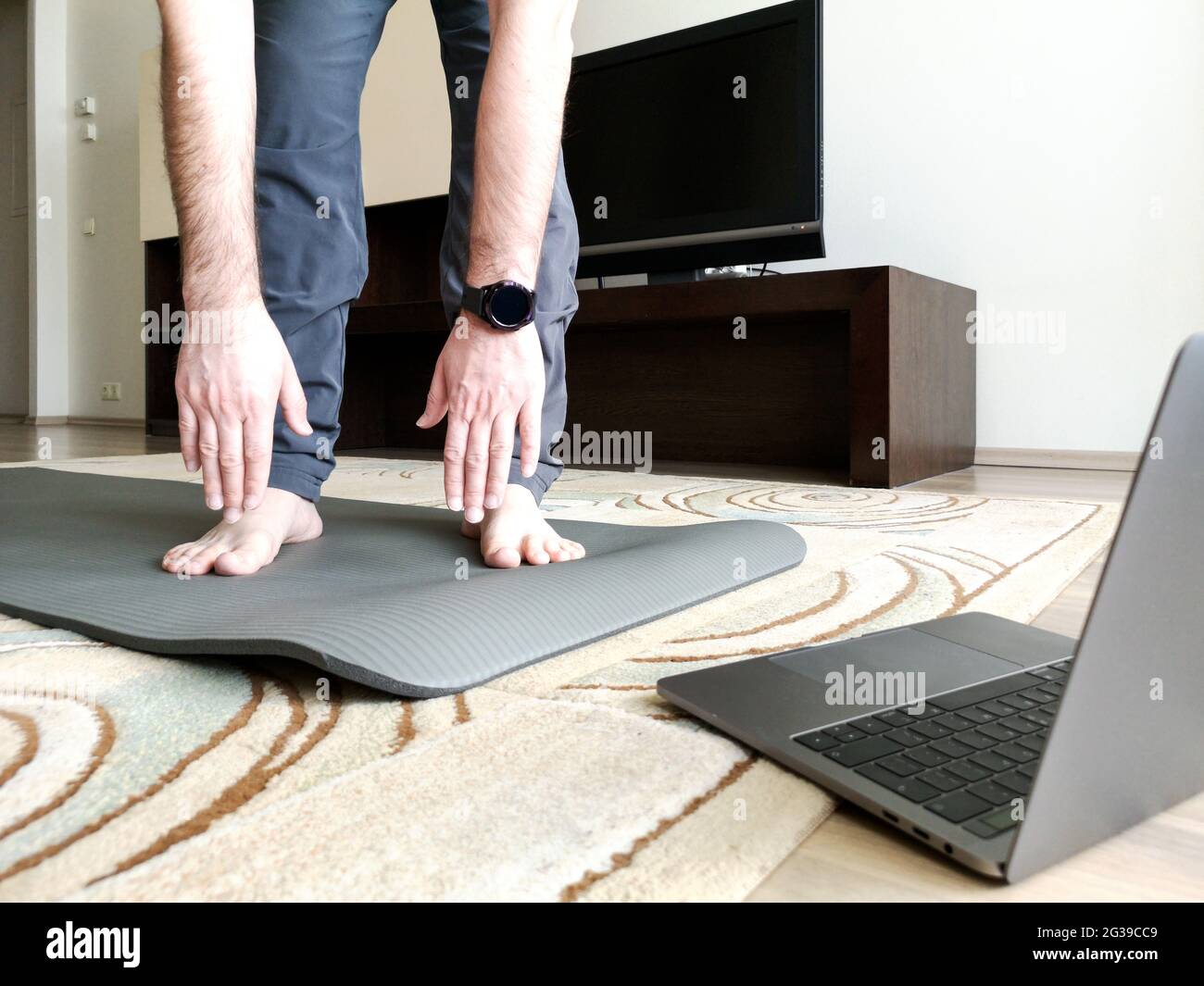 Man does stretching at home online, tilting downwards Stock Photo - Alamy