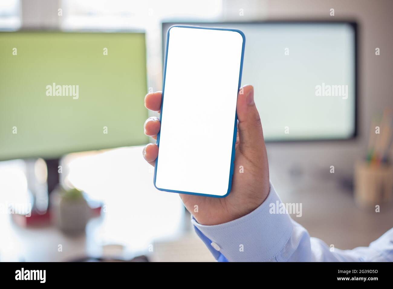 Closeup shot of a businessman holding his phone with a blank screen on ...