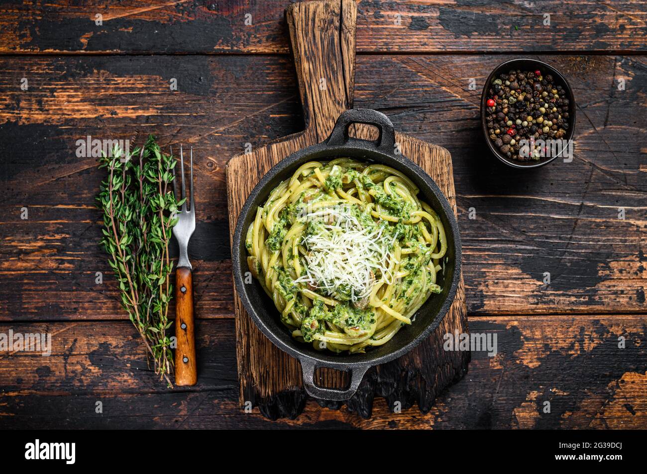 Spaghetti Pasta with pesto sauce, spinach and parmesan in a pan. Dark ...