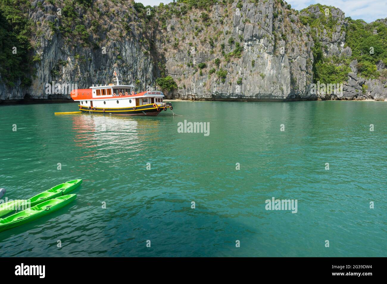 A tour boat in a narrow bay at Ha Long Bay, Vietnam Stock Photo - Alamy