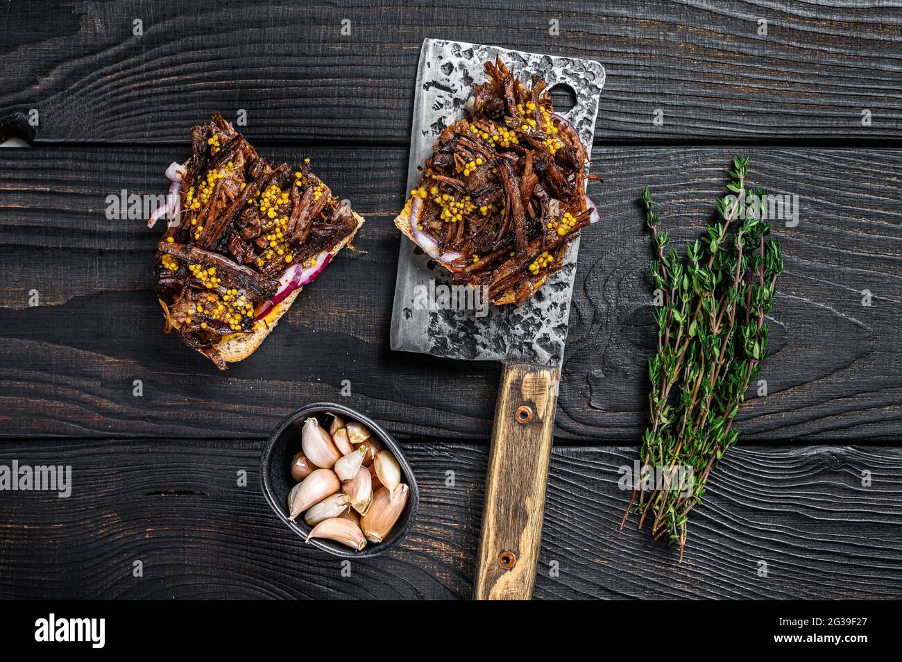 Brisket Sandwich with smoked beef meat on a meat cleaver. Black wooden ...