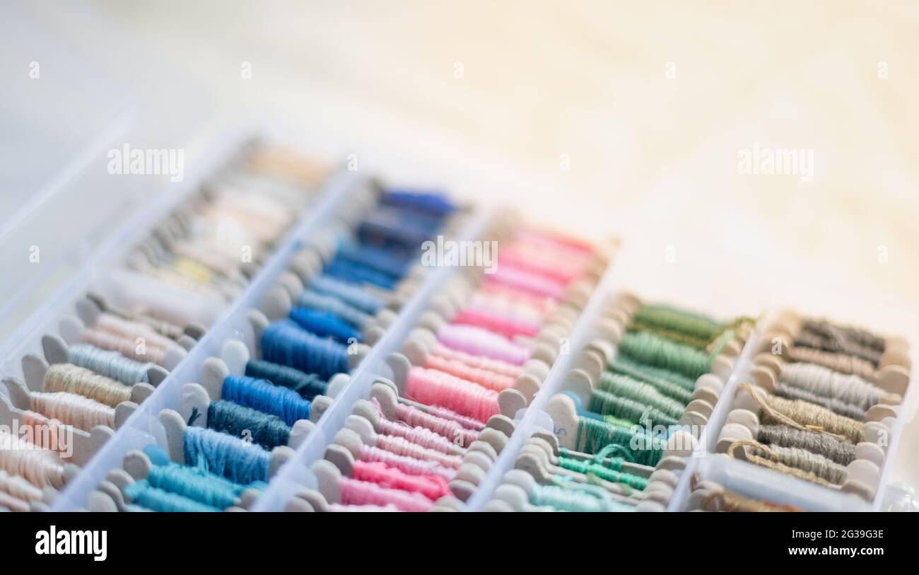 Closeup image of the colorful thread yarn swatch with the plastic box ...