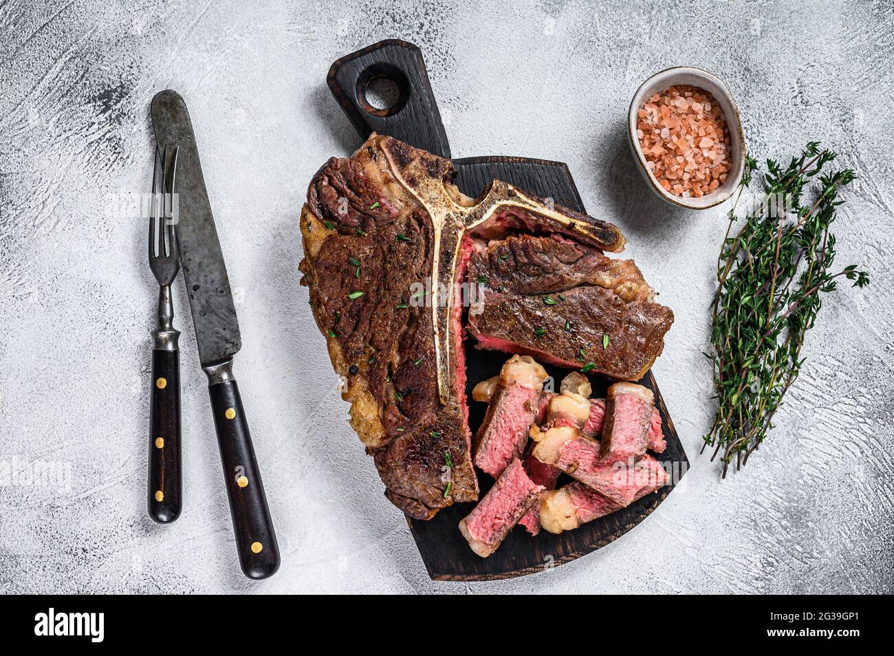 Sliced Grilled T-bone beef meat Steak on a wooden cutting board. White ...