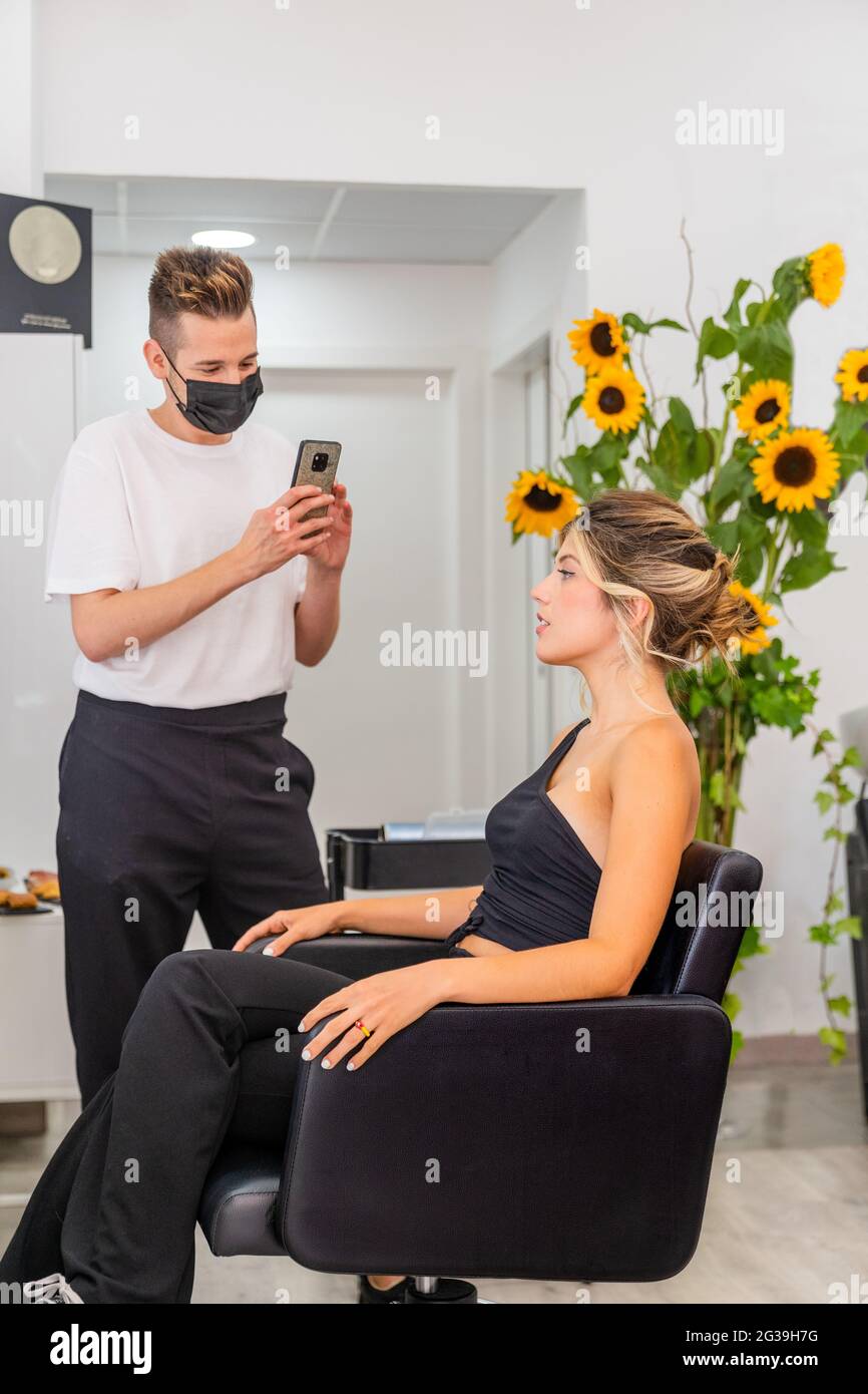 Hairdresser taking a photo with the cell phone of a beautiful Caucasian ...