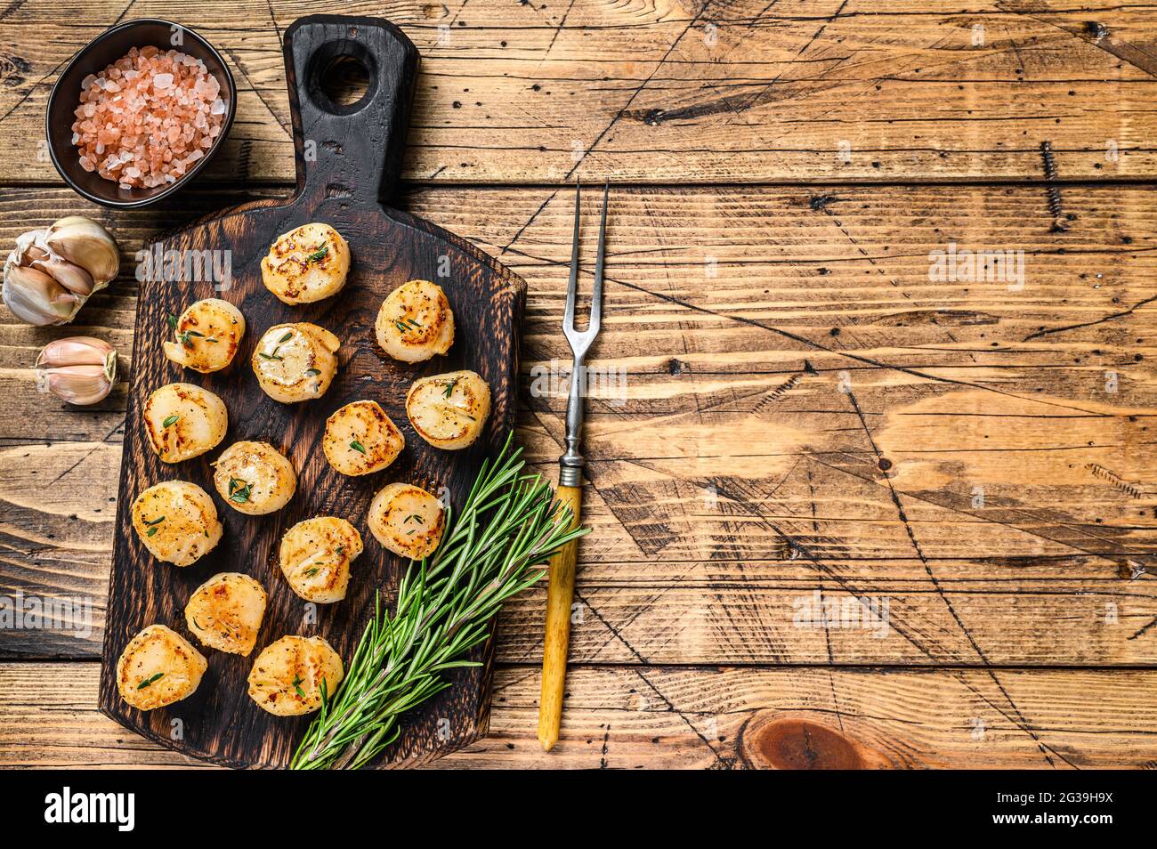 BBQ Seared scallops with butter sauce on a wooden board. wooden ...