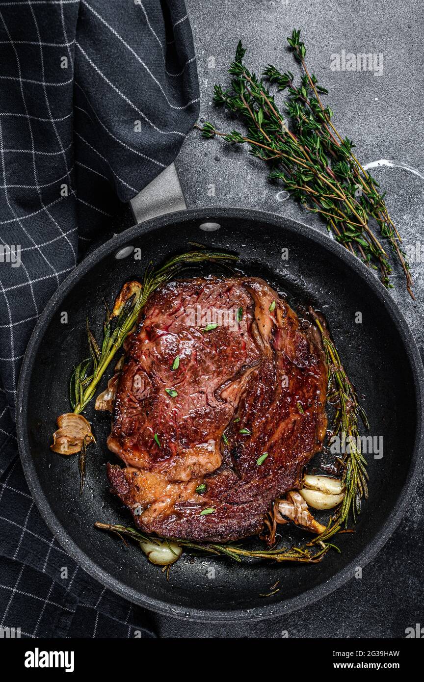 Roasted rib eye steak, ribeye beef meat in a pan. Black background. Top ...