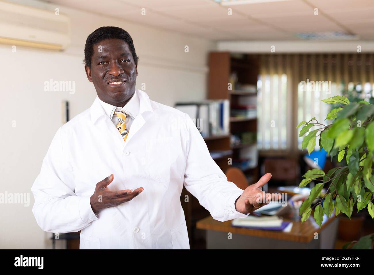 African american man doctor standing in medical office making welcoming ...