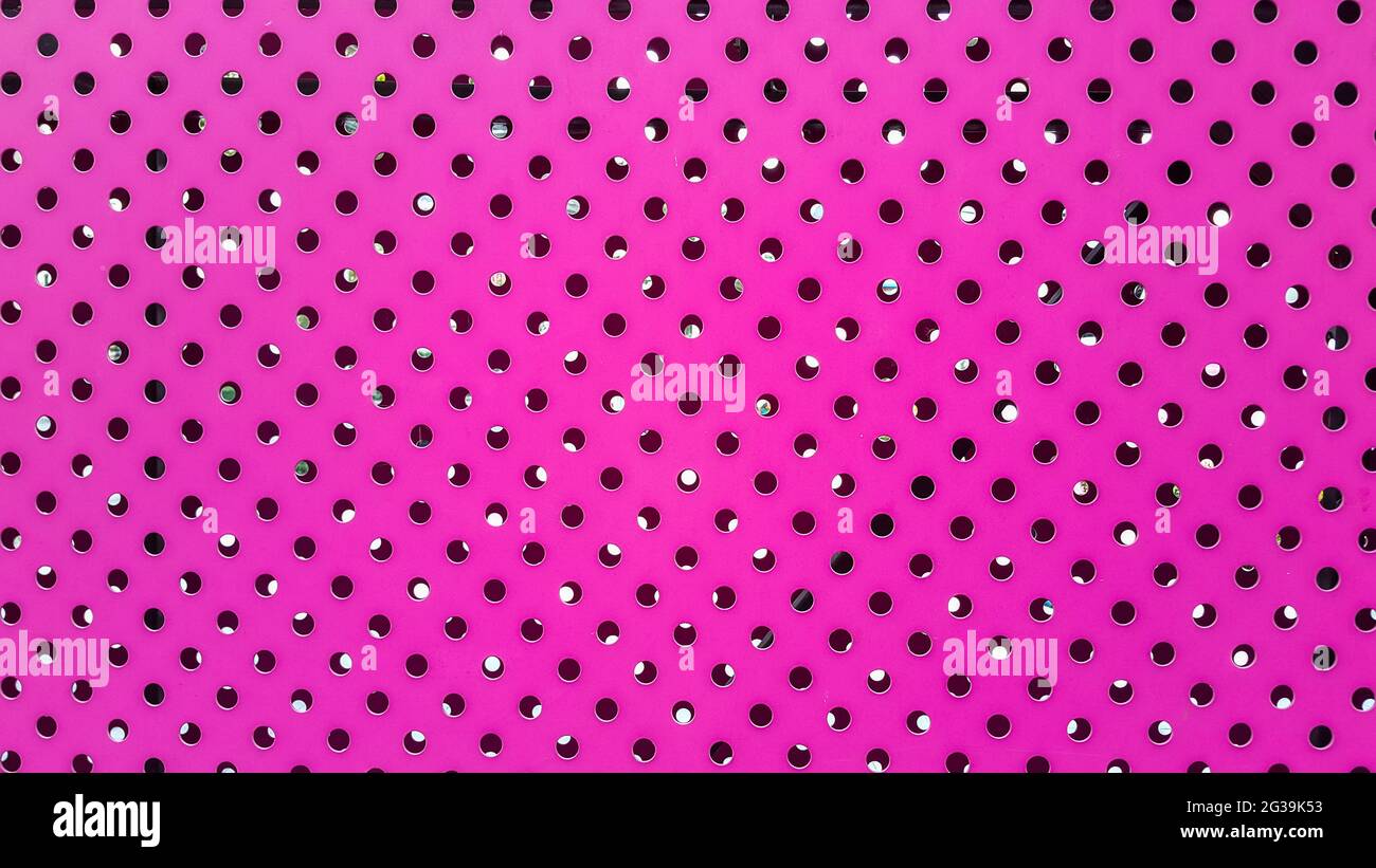 Pink sheet metal with holes background Stock Photo - Alamy