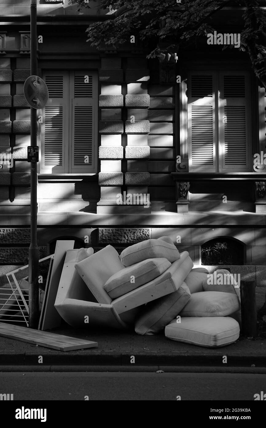 Vertical grayscale shot of cushions and sofa seats outdoors on the ...