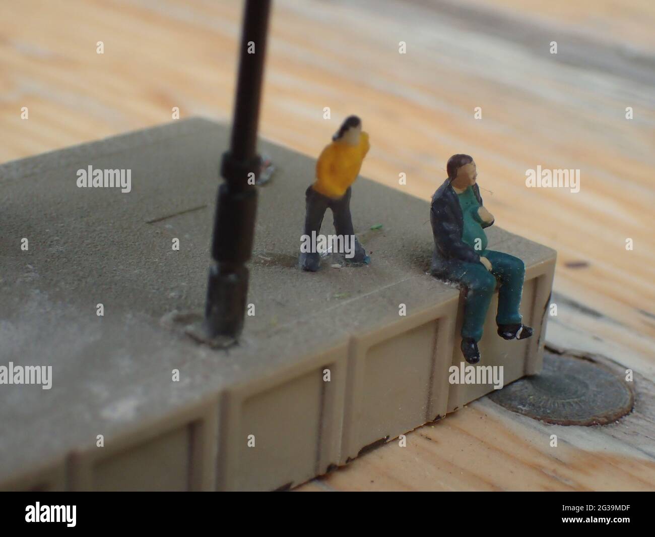 High angle shot of small figures of people on a wooden surface Stock ...