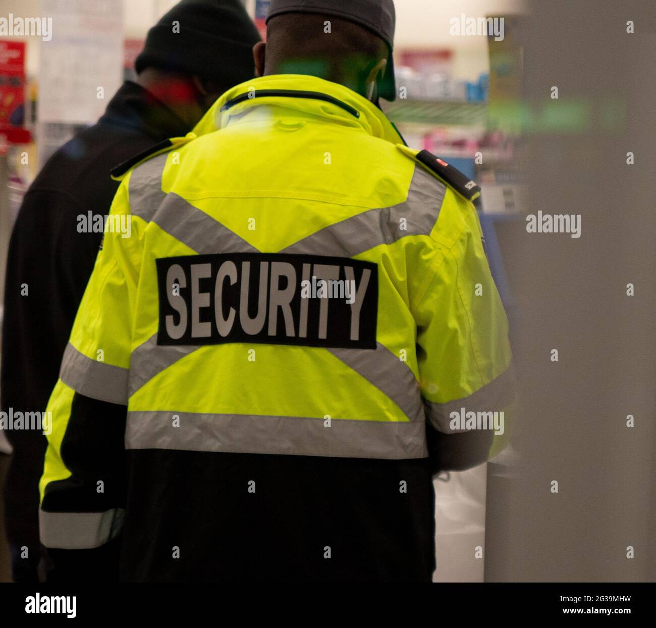 Rear view of a security guard in uniform patrolling in a commercial ...