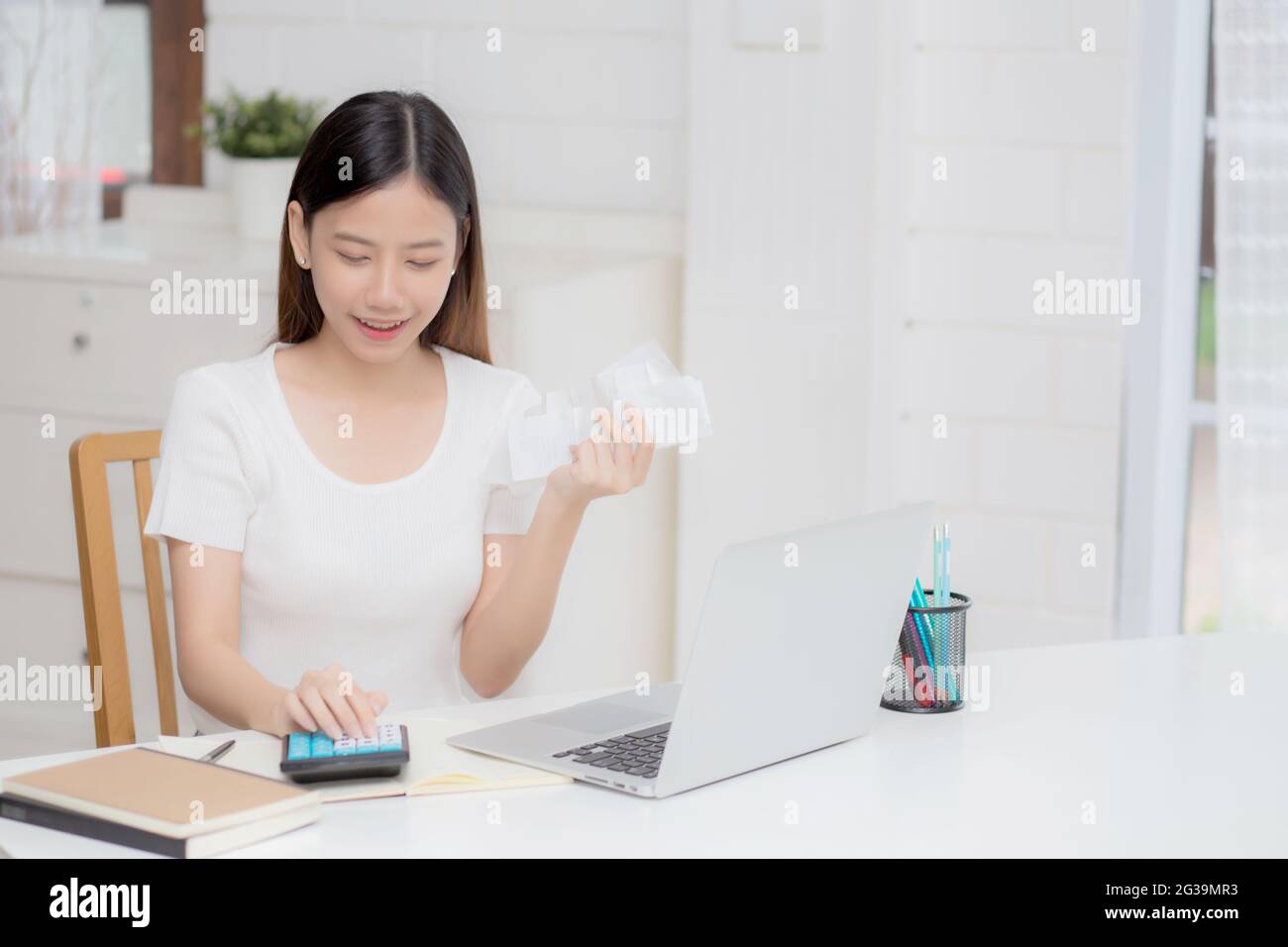 Young asian woman calculating finance household with calculator on desk ...