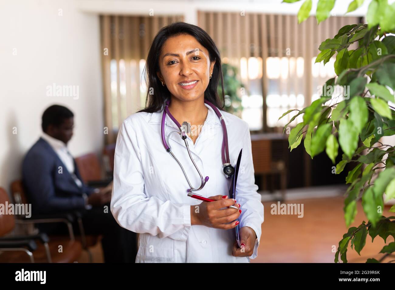 Portrait of female doctor wearing uniform and stethoscope with folder ...