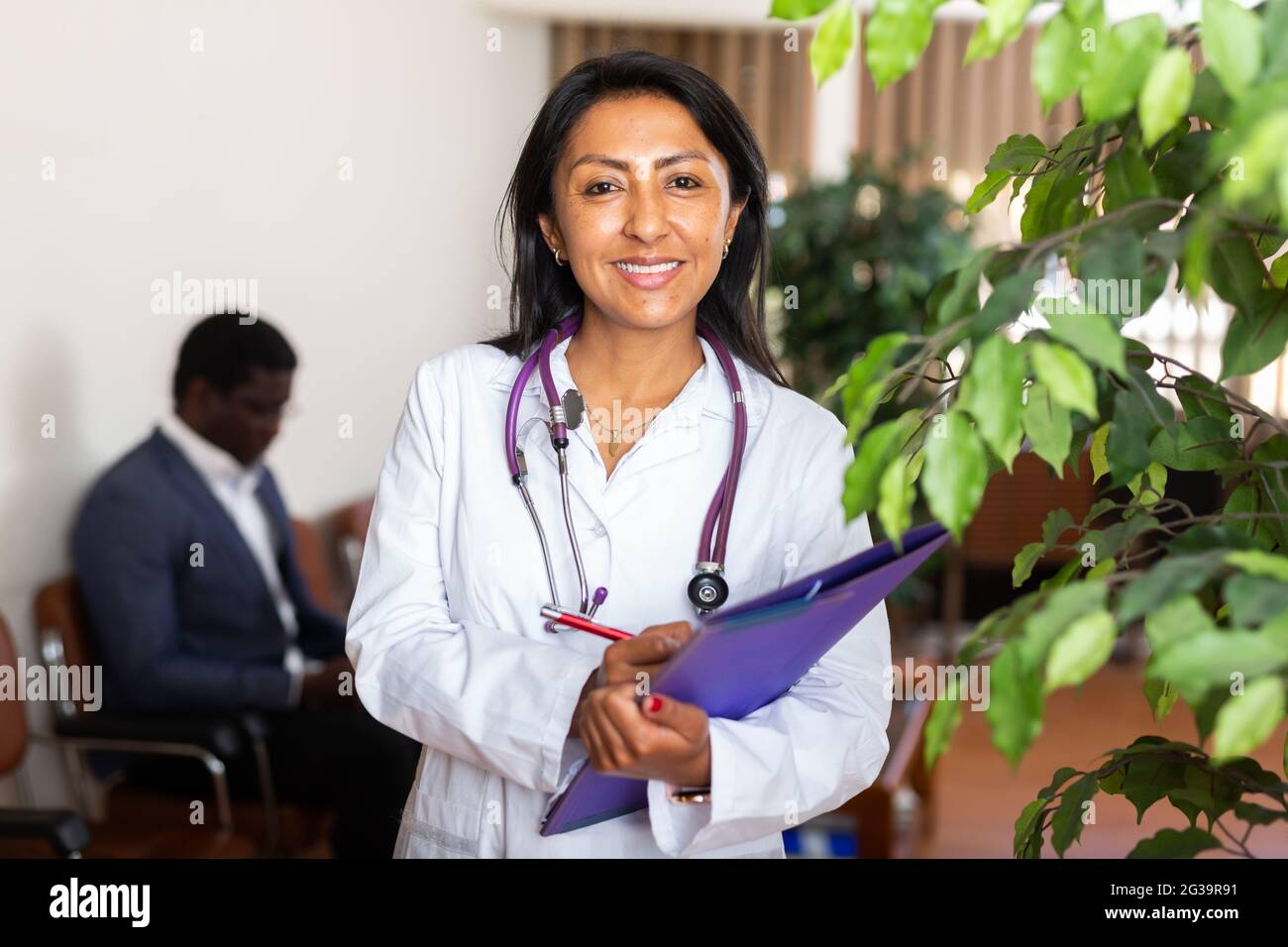 Polite female doctor filling out medical form at clipboard Stock Photo ...