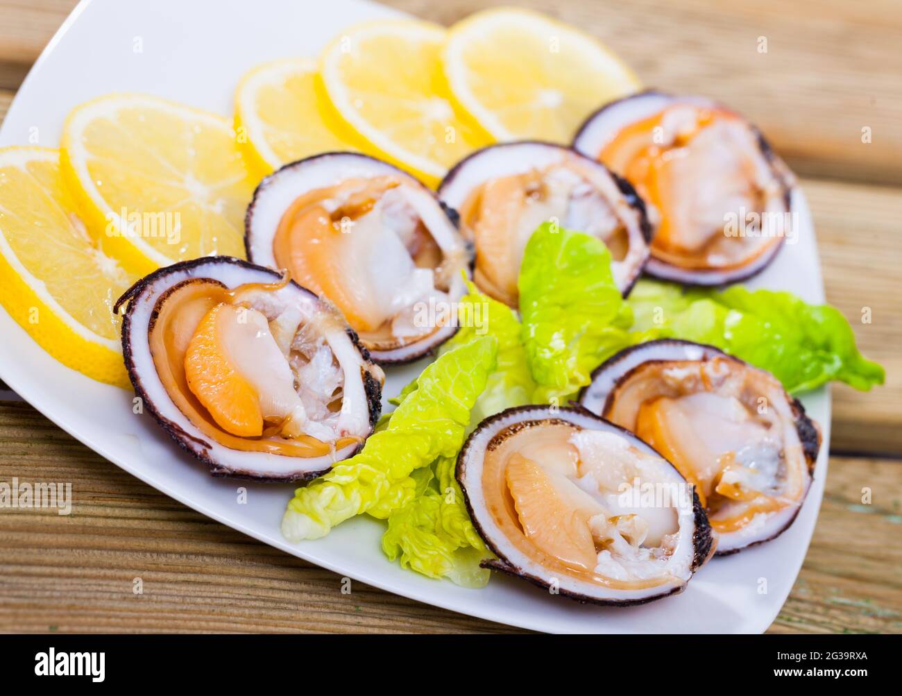 Raw bivalve shellfishes with lemon Stock Photo - Alamy