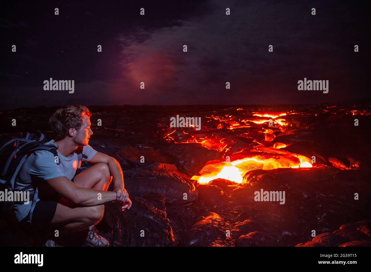 Lava flow man hiker on night hike watching magma erupting flowing from ...