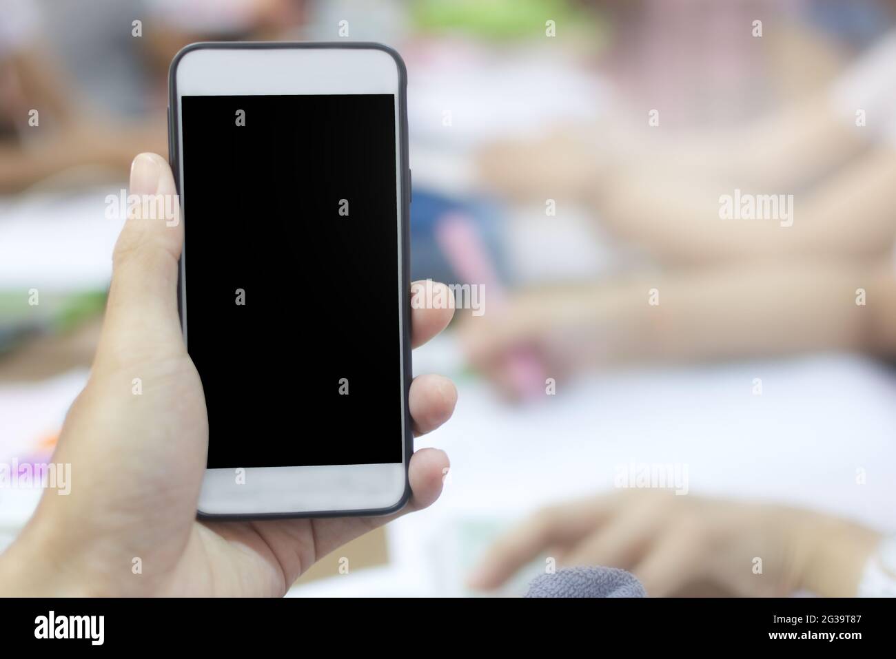 Hand holding smartphone with staff working Stock Photo - Alamy