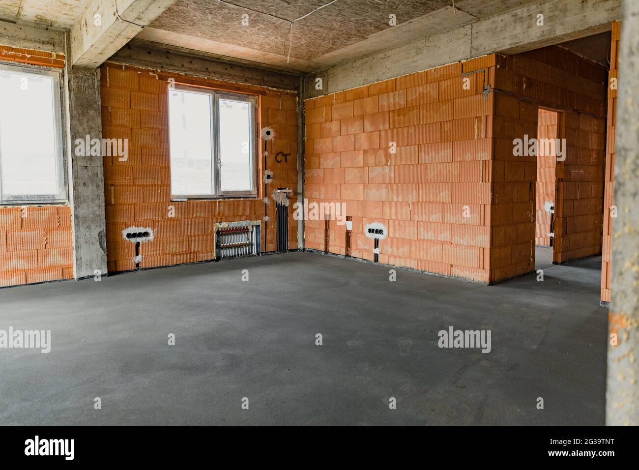 Indoor construction site with a big window, brown bricks and concrete ...