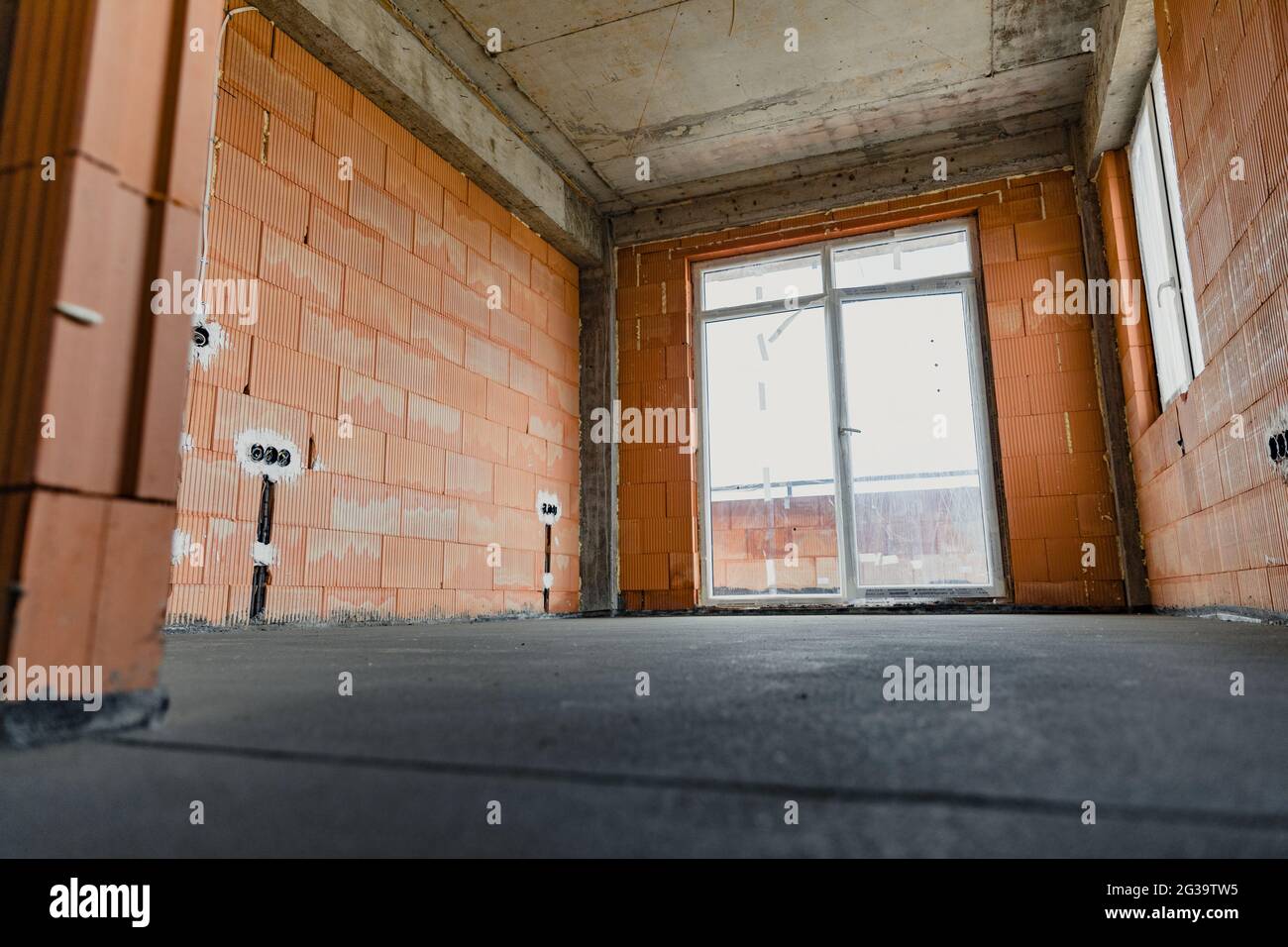 Indoor construction site with big windows, brown bricks and concrete ...