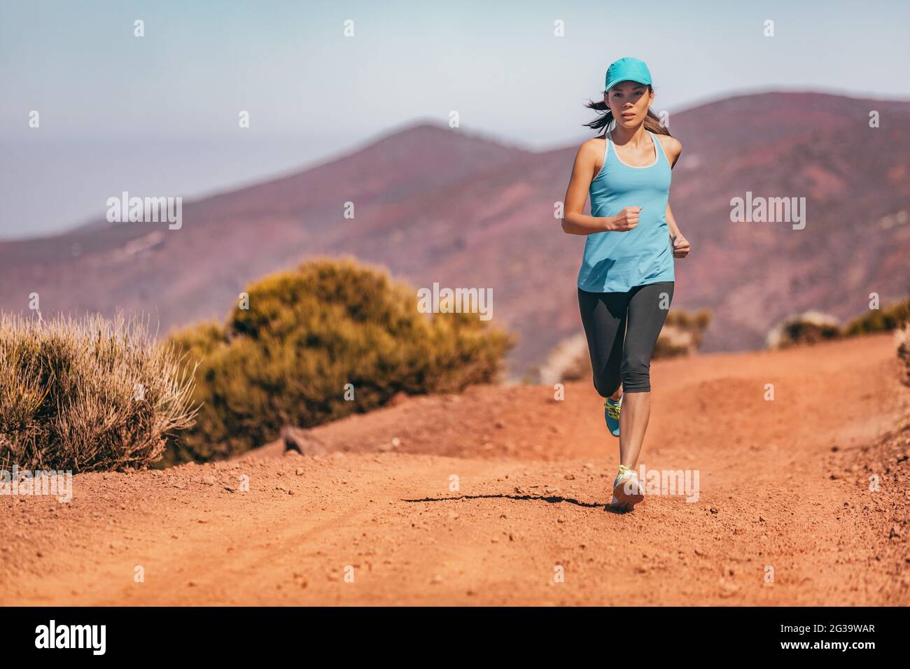 Running sports athlete woman trail runner wearing cap shoes leggings ...